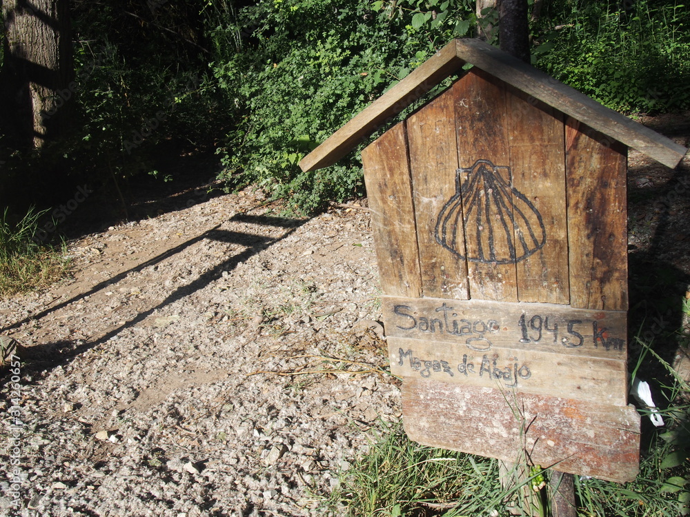 Wooden signboard with scallop shell mark on the road to Santiago de ...