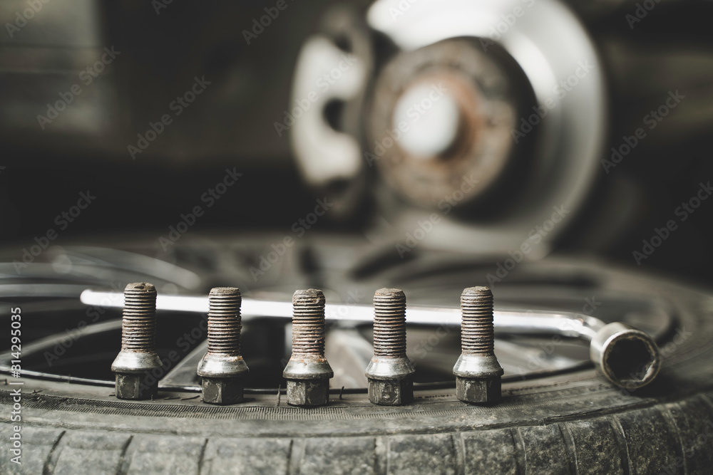 Wheel bolts on a wheel in straight line. Break disck of a car and a ...