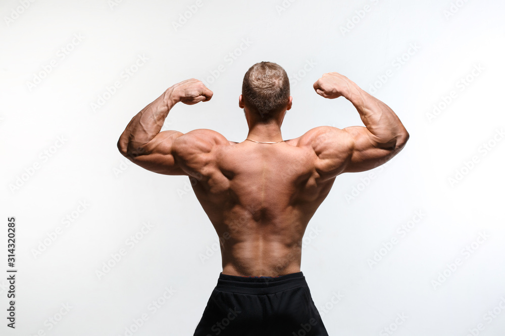 Muscular bodybuilder shows his muscles isolated on a white background ...