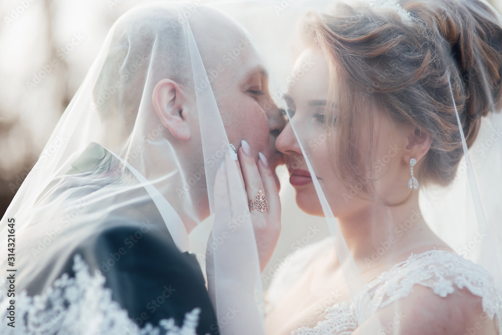 Bride and groom covered with veil close-up. Happy bride and groom on ...