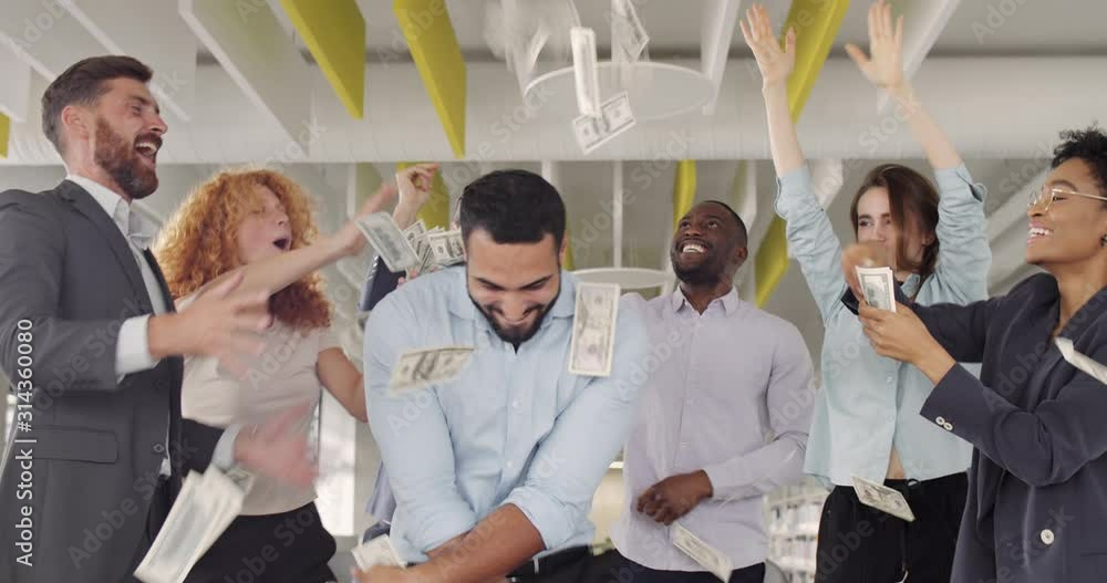 Happy businessman and his team celebrating victory and big profit at ...