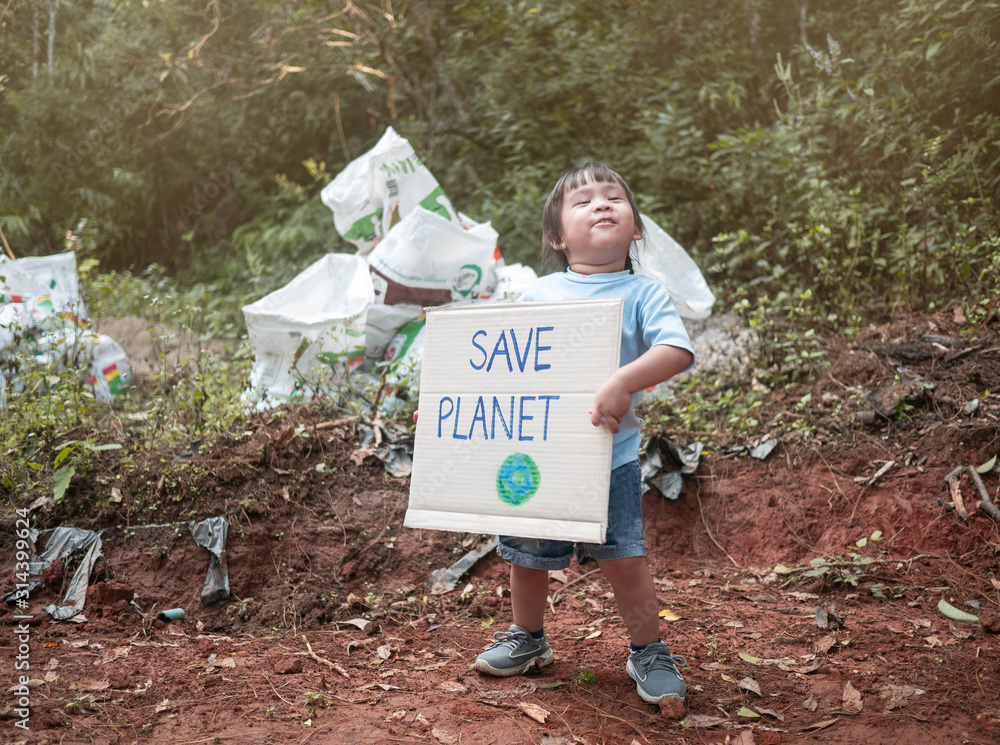 The little child girl holding "Save the planet" Poster showing a sign ...
