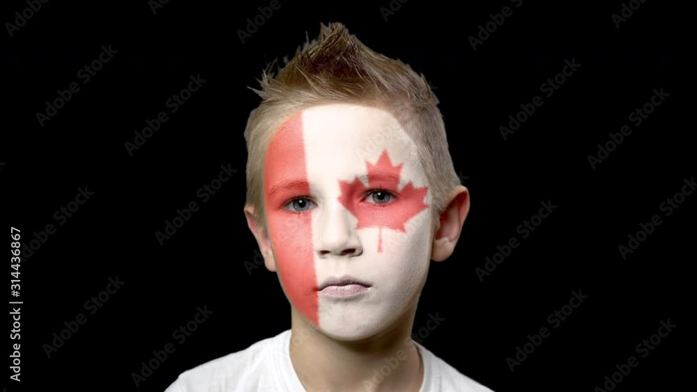 Sad fan of the football team of Canada. A child with a face painted in ...