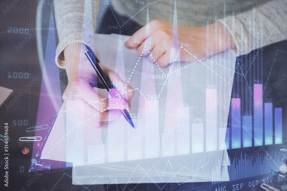Hand taking notes in notepad. Forex chart holograms in front. Concept ...