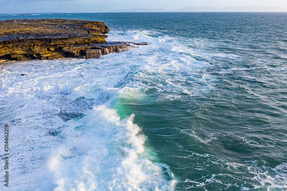 Aerial view of huge waves breaking at Muckross Head - A small peninsula ...