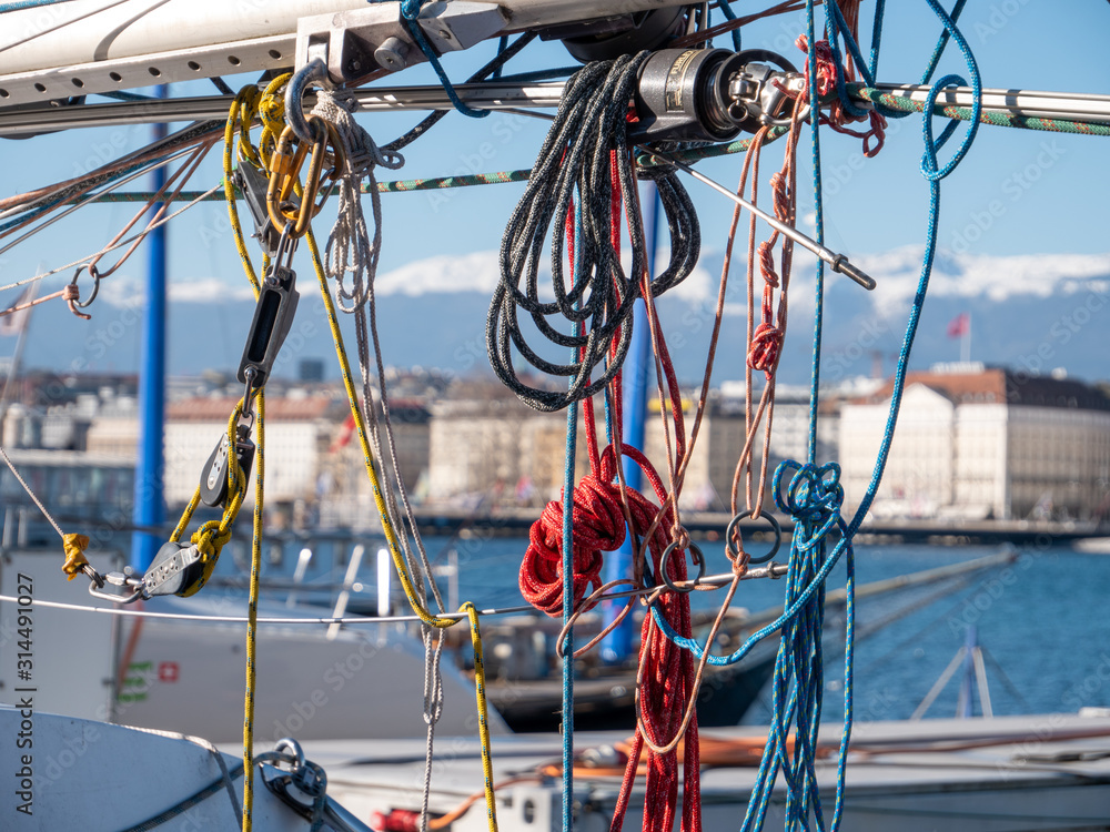 ropes and sailing lines hang down from a boat mast. The multicolored ...