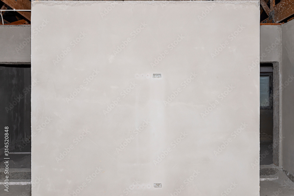 Freshly plastered partition wall built to hang the TV, visible sockets ...