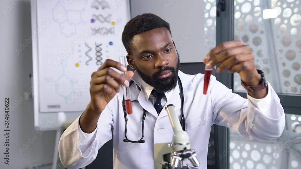 Concentrated experienced african american medical worker comparing two ...