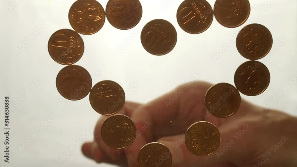 View from below as the hand throws gold coins. Moves them, collects ...