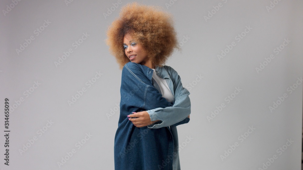 portrait in studio mixed race black woman in denim oversized shirt and ...