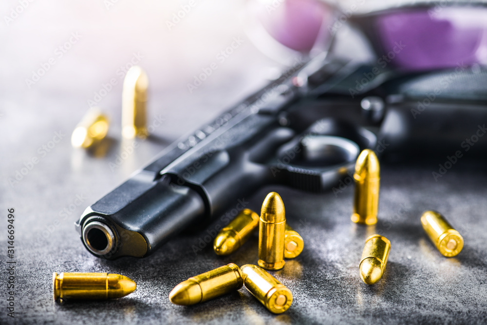 Hand gun with ammunition on dark stone background with tactical glasses ...