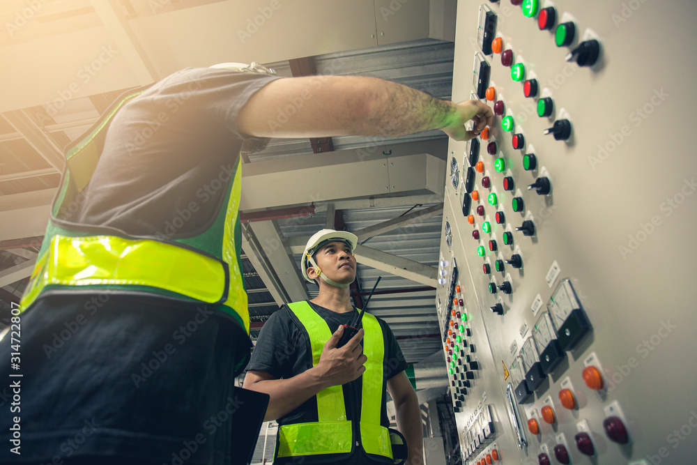 Two Electrical Engineer team working front control panel, Engineer ...
