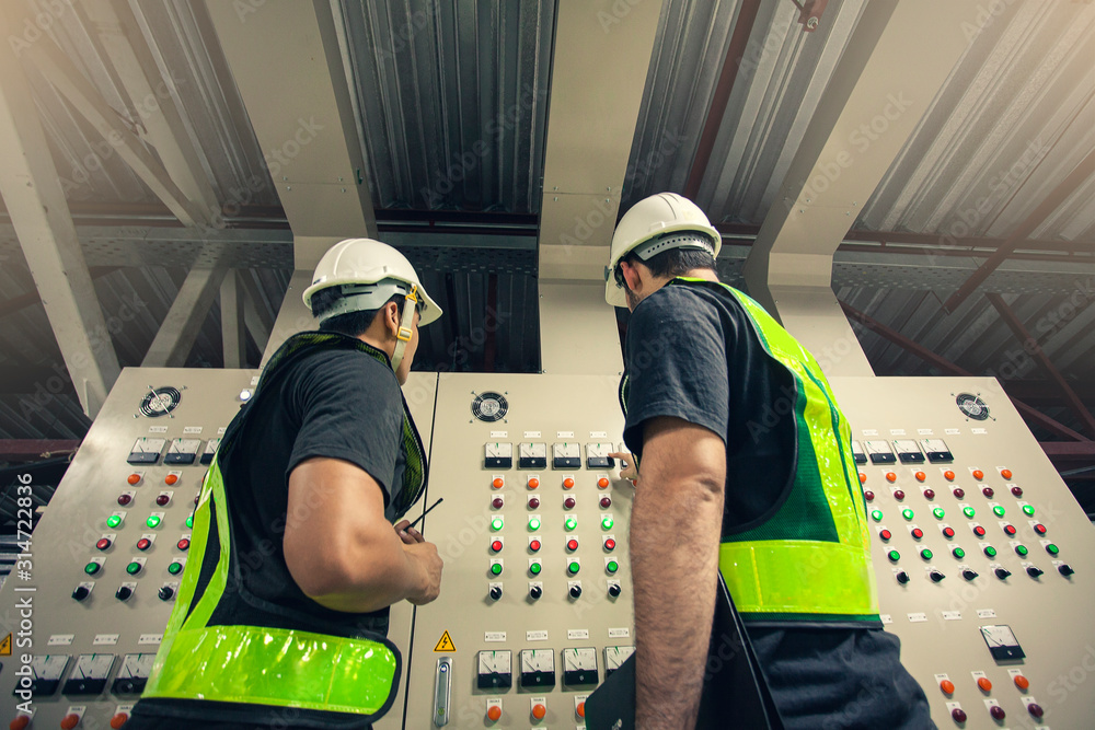 Two Electrical Engineer team working front control panel, Engineer ...