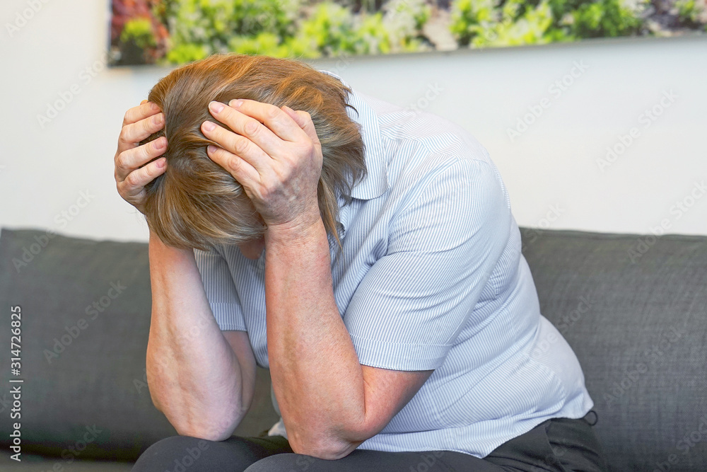 Sad senior woman hugged her head in her hands, mourning something ...