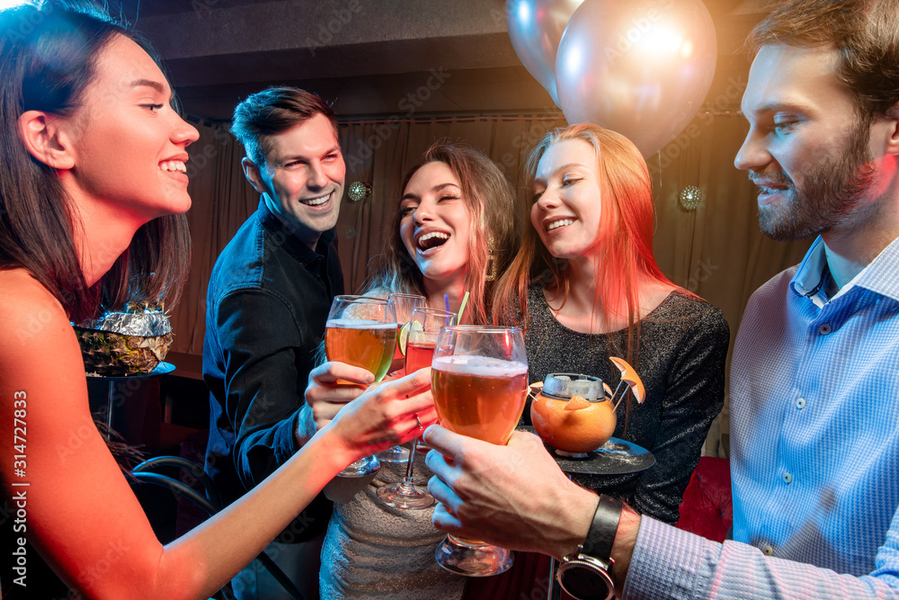 young friends drink and have fun togeher in karaoke bar, beautiful ...