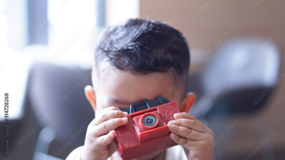 Little Asian boy holding plastic toy camera and take picture.Concept ...