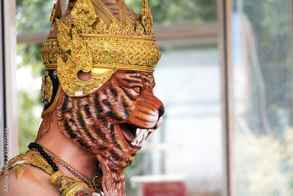 Statue of a man with a tiger mask at Buddhist temple. The Thai Lersi ...