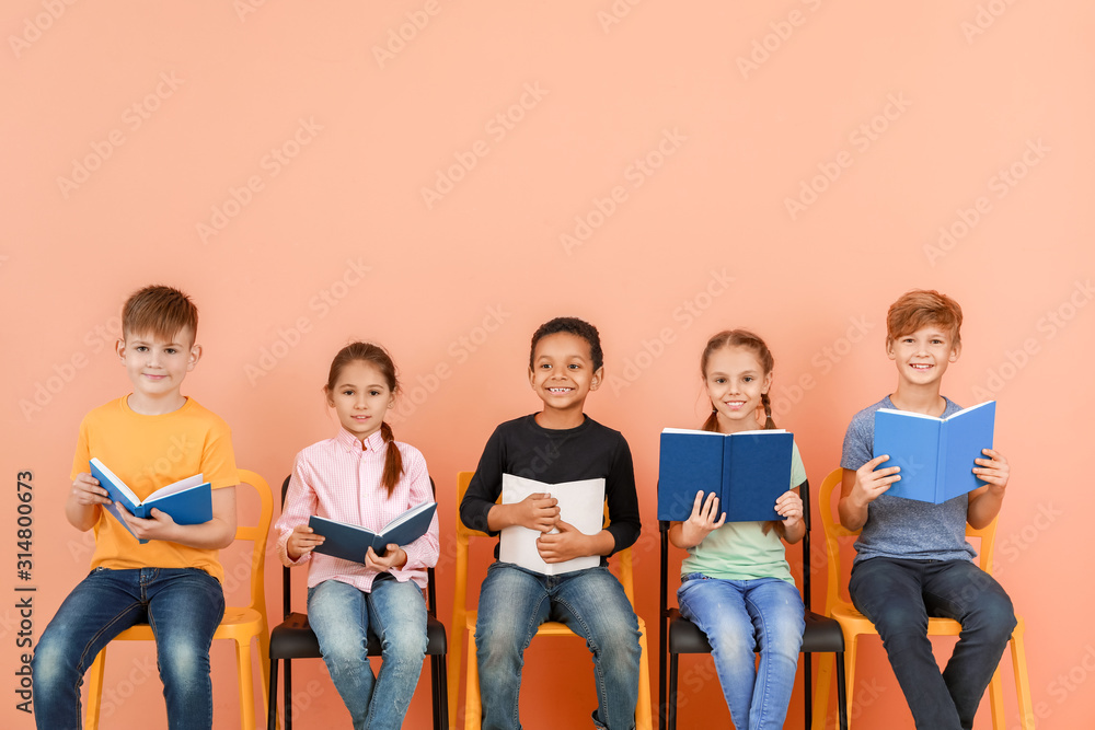 Cute little children reading books on color background Stock Photo ...