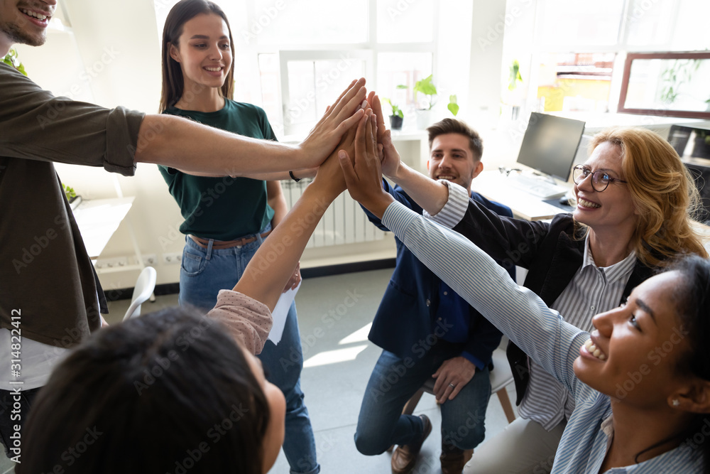 Staff giving high five congratulating each other with corporate ...