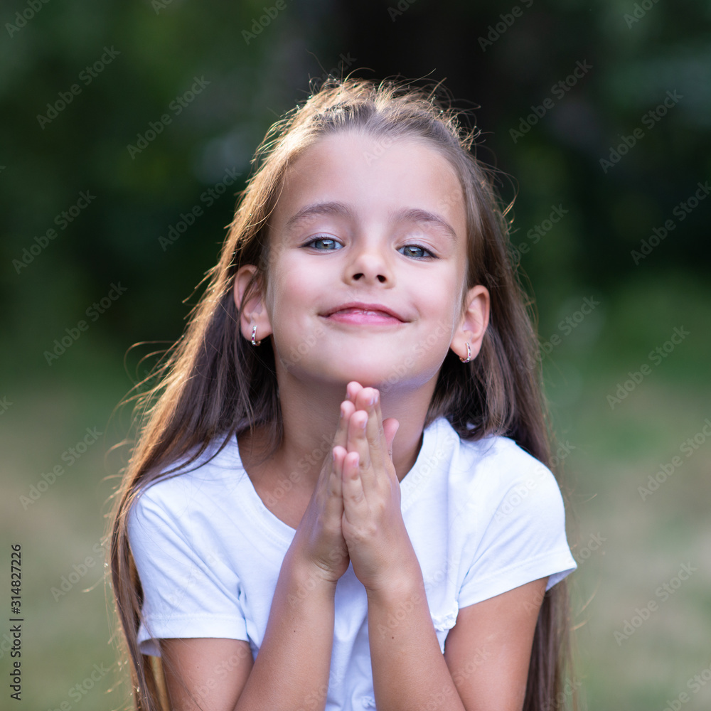 Praying little girl, summer nature outdoor. Happy smiling kid feels ...