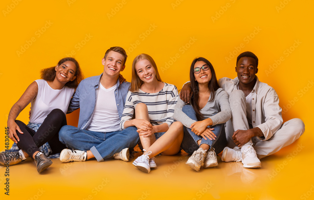 Joyful students having fun over yellow studio background Stock Photo ...