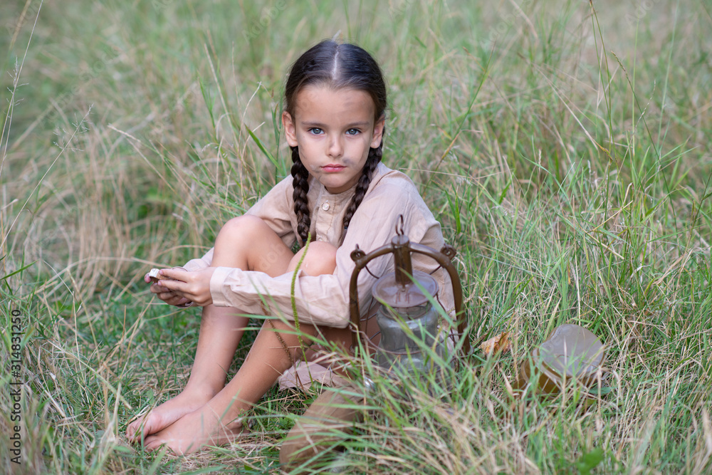 Little girl with long pigtails and beautiful dirty face sitting at ...