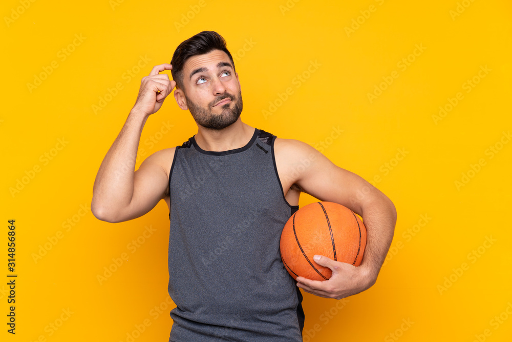 Handsome young basketball player man over isolated white wall having ...