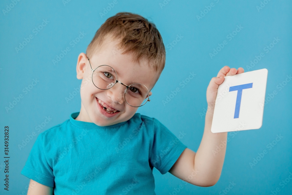 Cute little boy with letter on blue background. Child learning a ...