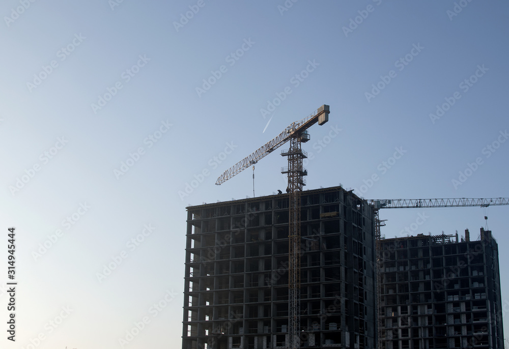 Hydraulic luffing jib tower cranes and workers being poured concrete ...