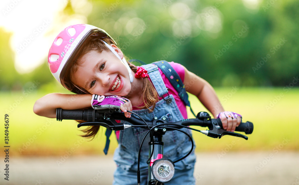 happy cheerful child girl riding a bike in Park in nature. Stock Photo ...