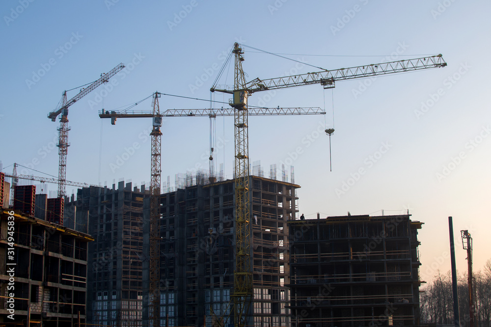 Hydraulic luffing jib tower cranes and workers being poured concrete ...