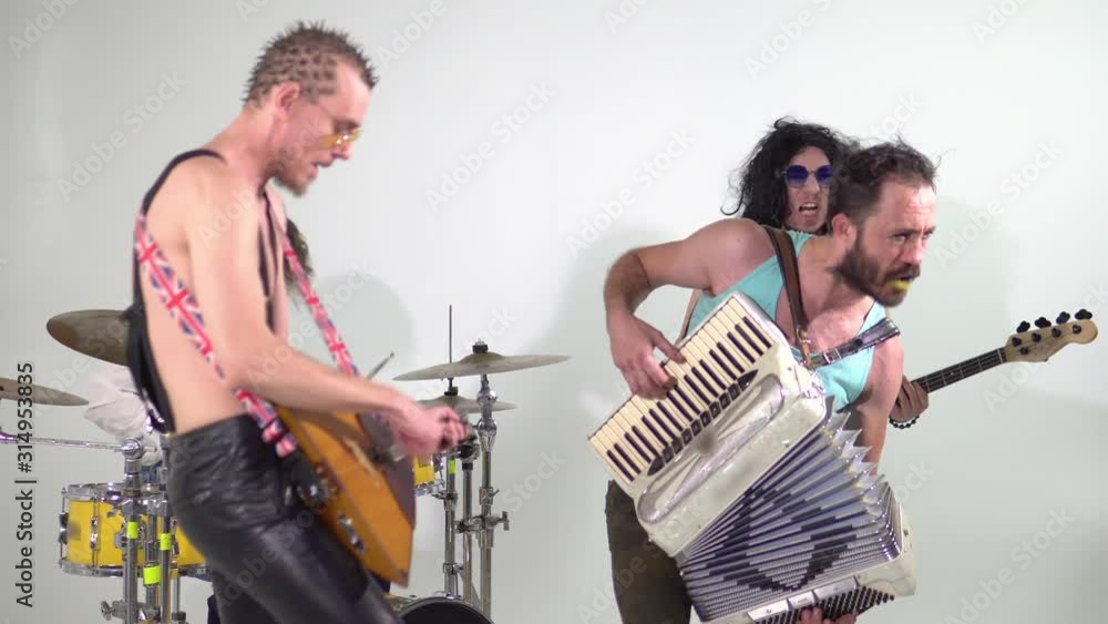 Punk rock band. Shooting a clip. Musicians are jumping with instruments ...