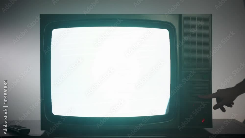 Vintage television in dark room with blinking white screen, noise ...