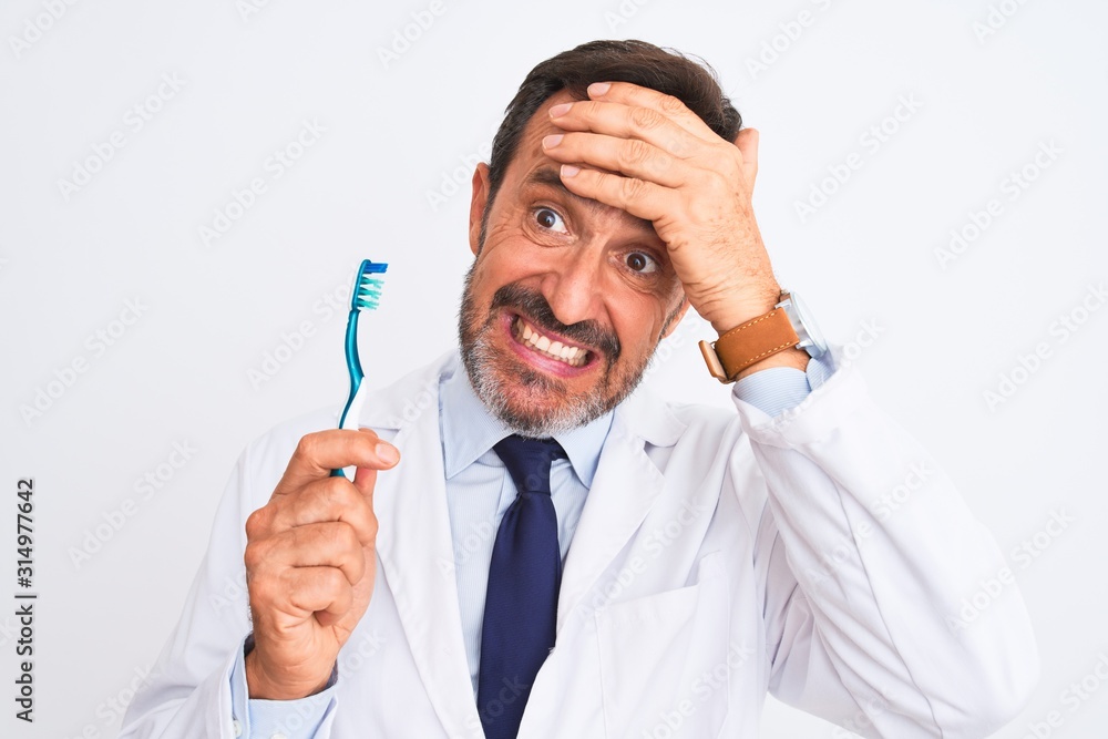 Middle age dentist man holding toothbrush standing over isolated white ...