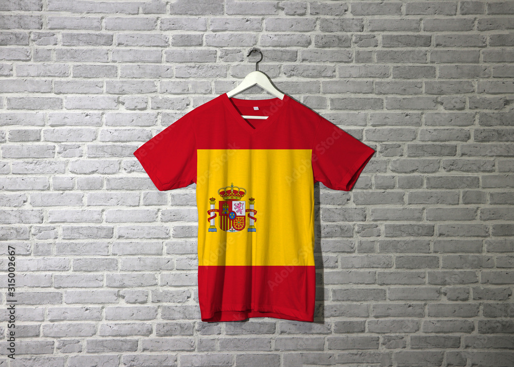 Spain flag on shirt and hanging on the wall with brick pattern ...