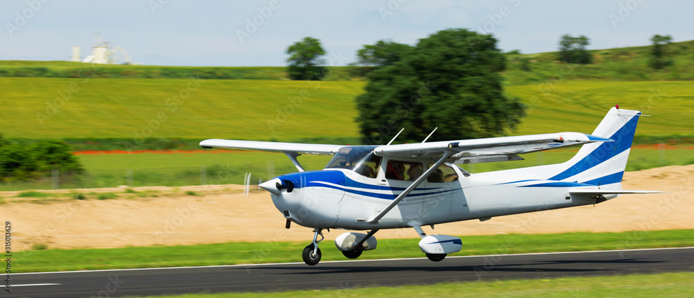 Light aircraft landing on aerodrome runway Stock Photo | Adobe Stock