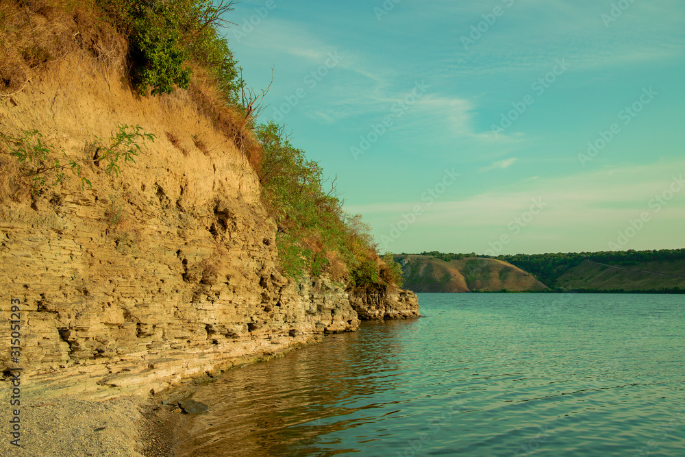 spring time nature reserve landscape rock above peaceful lake water ...