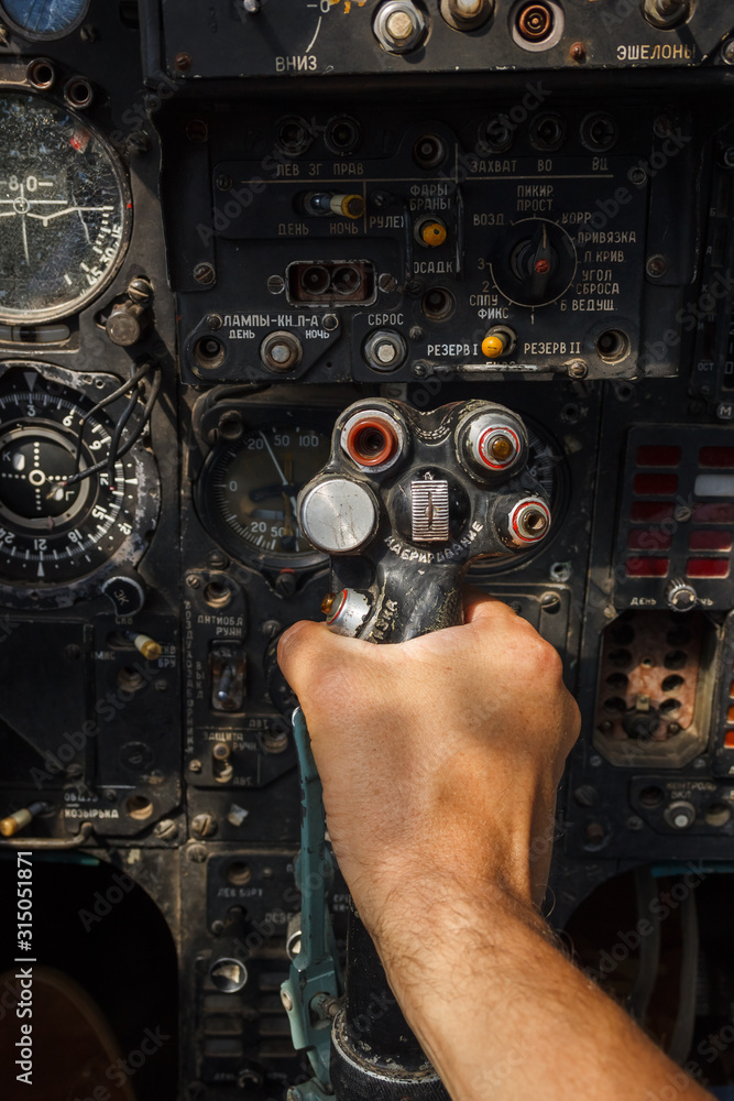 Pilot's hand on the military aircraft control knob. In the cockpit of ...