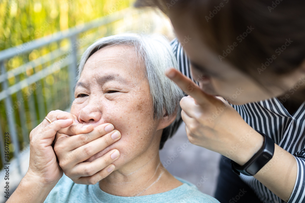 Angry asian woman covering senior mouth and showing silence gesture ...
