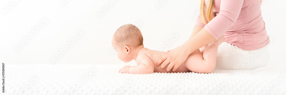 Baby massage banner. Young therapist giving a baby boy a back massage ...