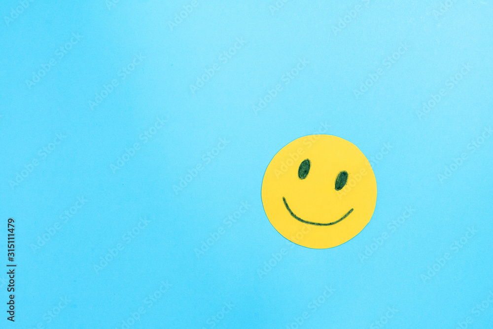 Yellow face smiling on blue background. Stock Photo | Adobe Stock