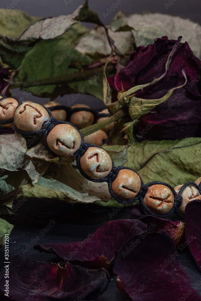 Vertical close-up on the runes of clay that lie on the flowers of a ...