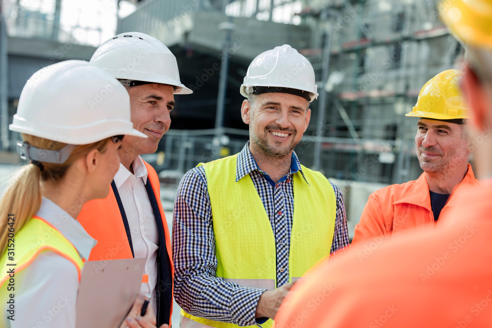 Smiling engineers construction workers meeting at construction site ... Smiling engineers construction workers meeting at construction site ...