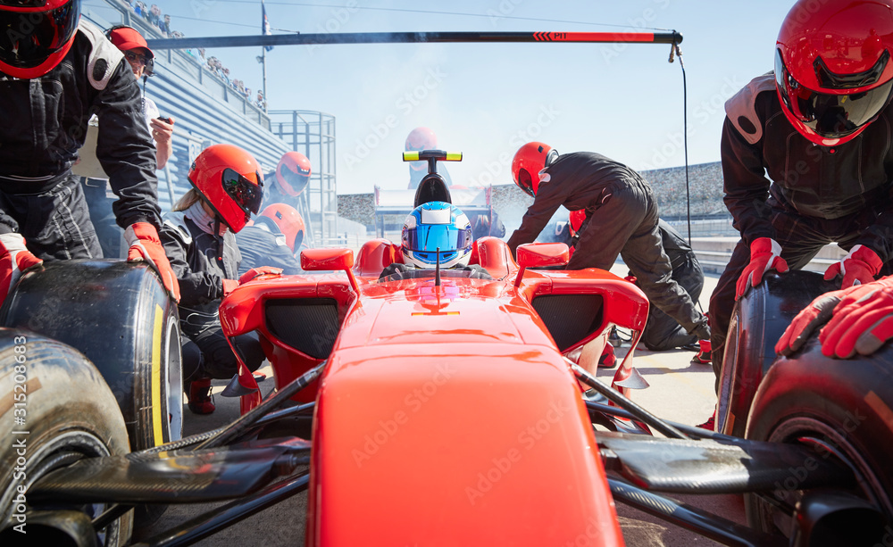Pit crew replacing tires on formula one race car in pit lane Stock ...