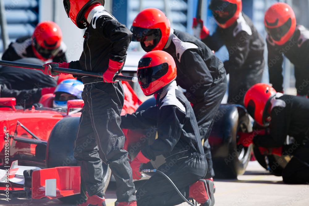 Pit crew replacing tires on formula one race car in pit lane Stock ...