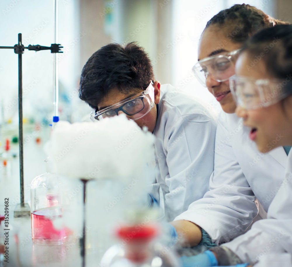 Students watching chemical reaction, conducting scientific experiment ...