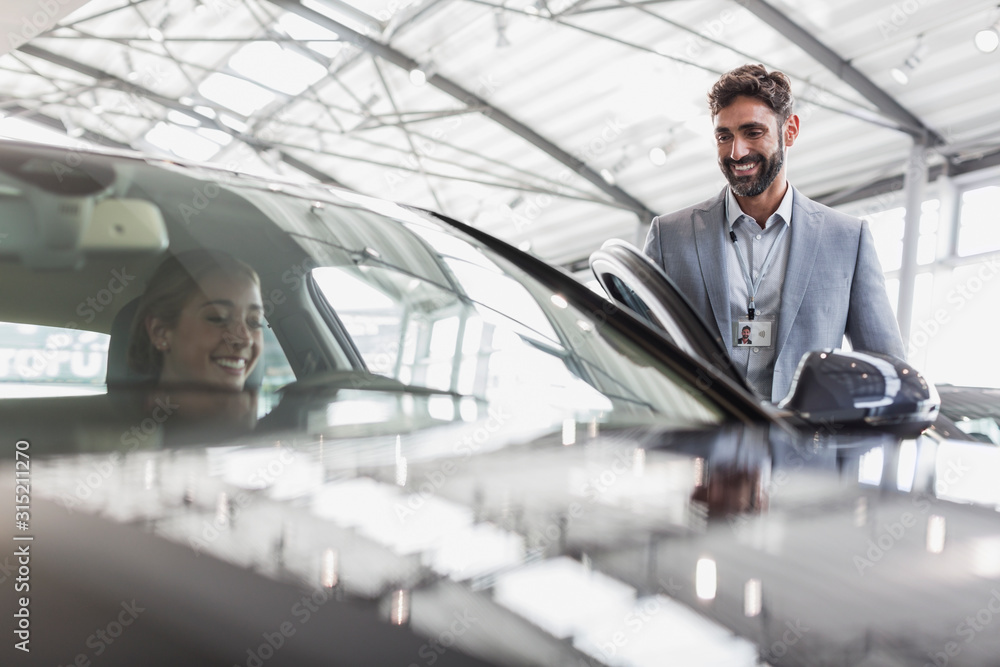 Fotografia do Stock: Smiling car salesman female customer in driver‚Äôs ...