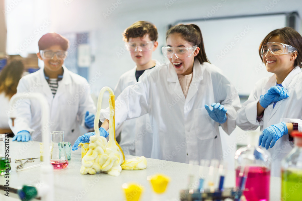Surprised students conducting exploding foam scientific experiment in ...