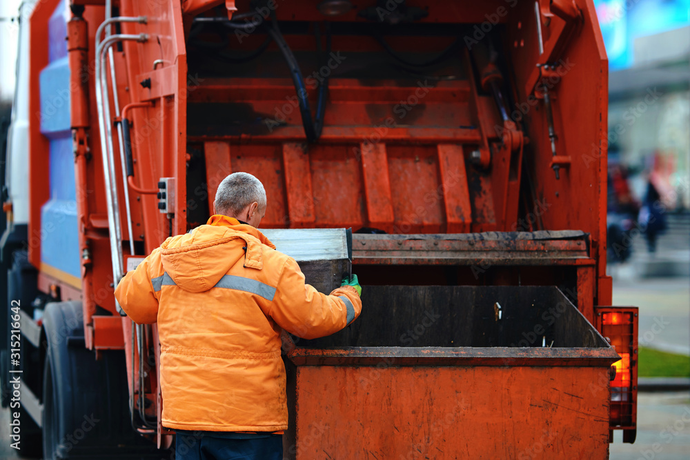 Municipal worker collect garbage. Man loading waste from trash bin in ...