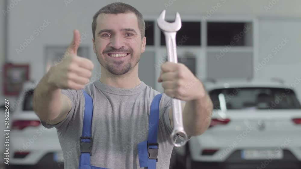 Portrait of cheerful Caucasian man with brown eyes showing thumb up ...